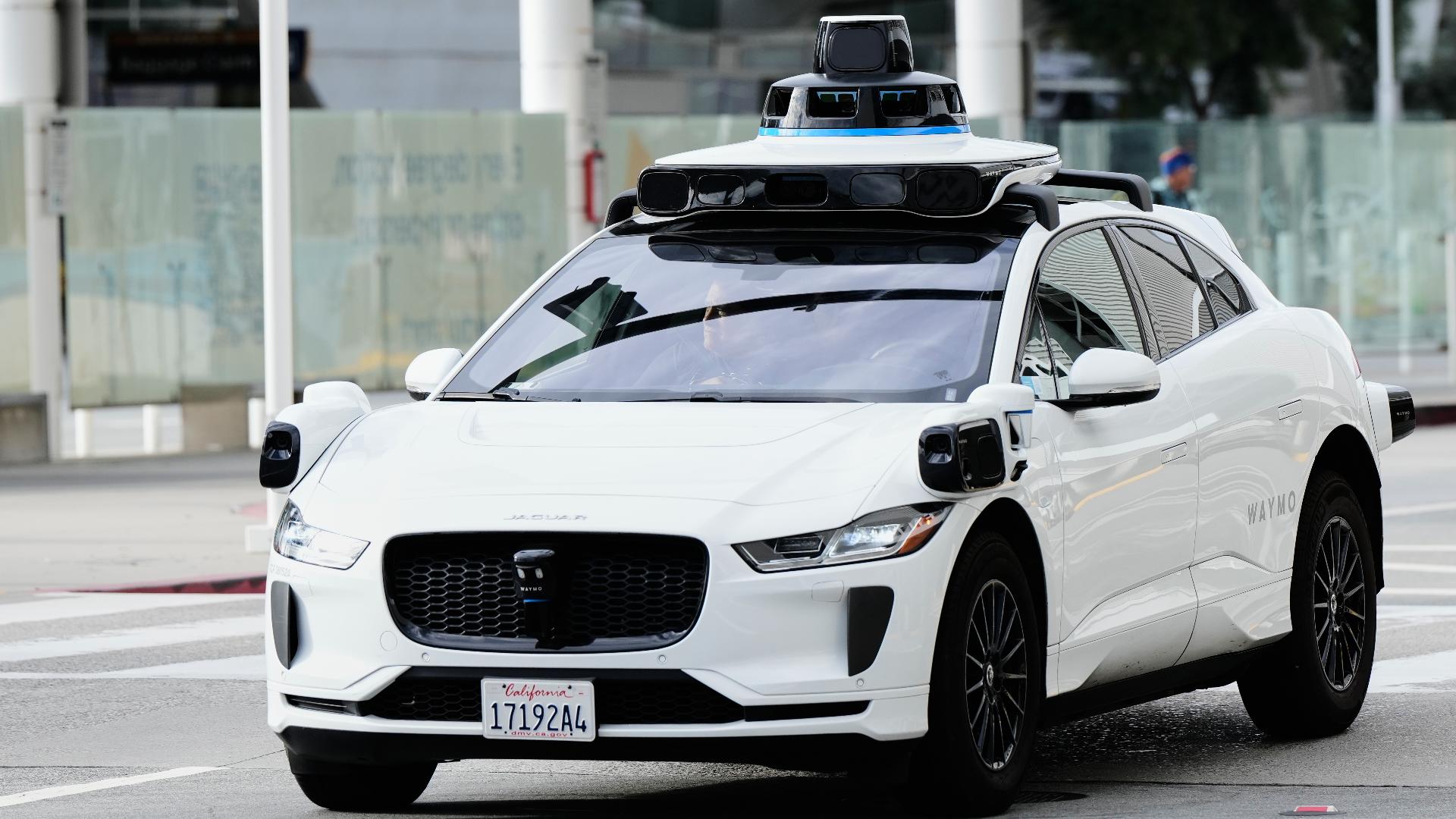 Watch: Driverless Waymo taxi rolls into active LAPD standoff in Los ...