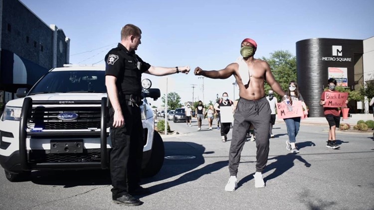 Photographer captures powerful fist-bumping moment between protester ...