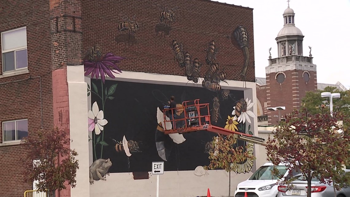 Matthew Willey painting bee mural in Scranton | wnep.com