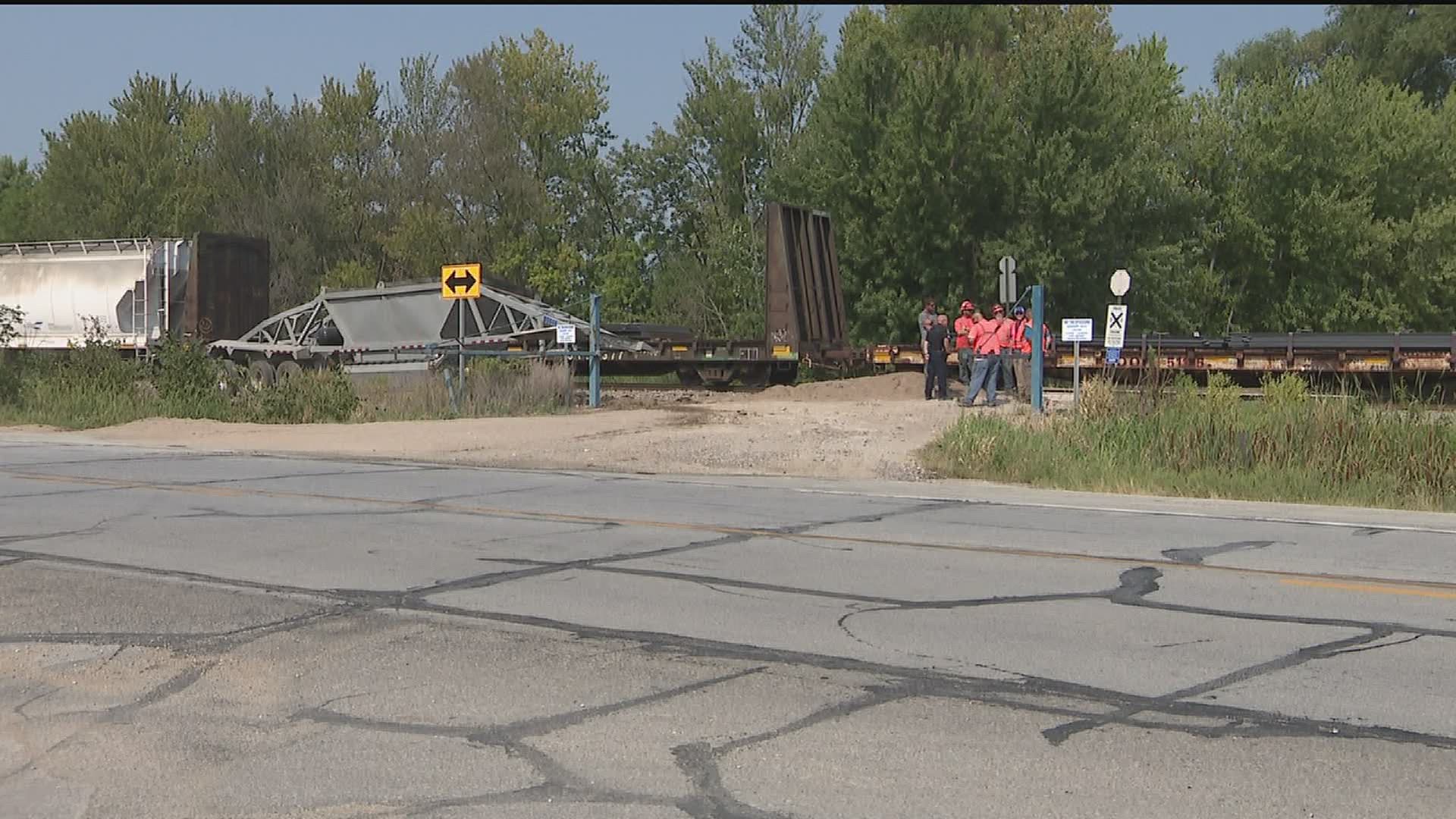 95,000 pounds of sand spills onto the ground after train hits semi in ...
