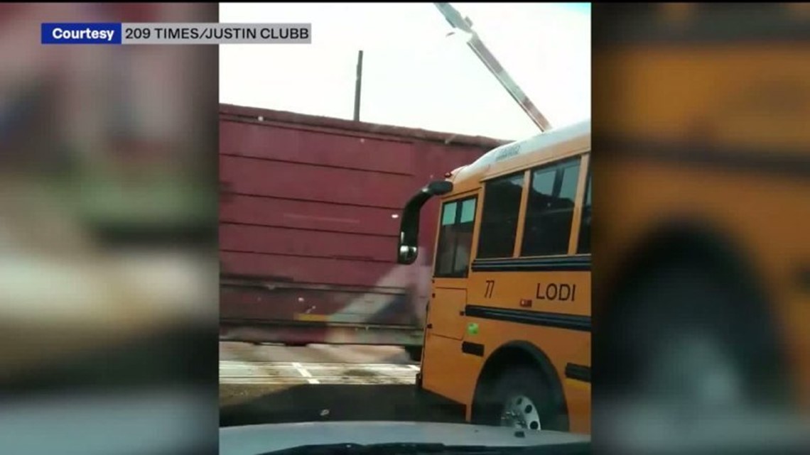 Video shows train narrowly miss school bus stopped under crossing arm ...