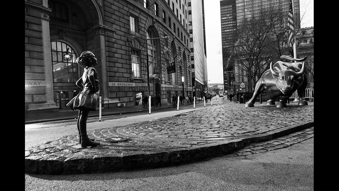 Statue of defiant girl staring down Wall Street bull appears day before ...